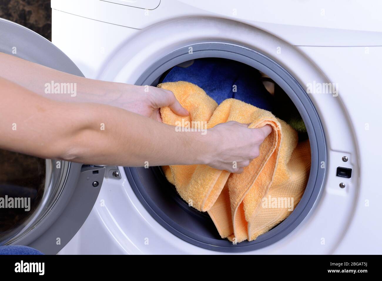 Washing machine loaded with clothes close-up Stock Photo - Alamy