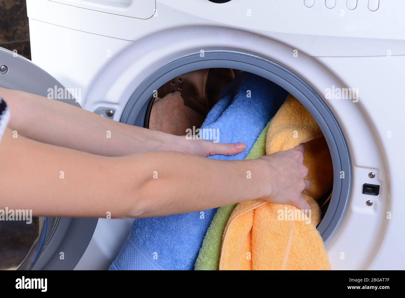 Washing machine loaded with clothes close-up Stock Photo - Alamy