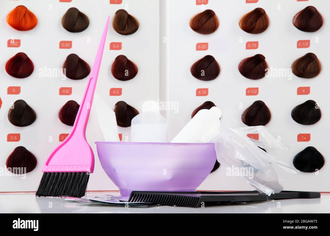 Hair dye kit on board with hair samples of different colors background ...