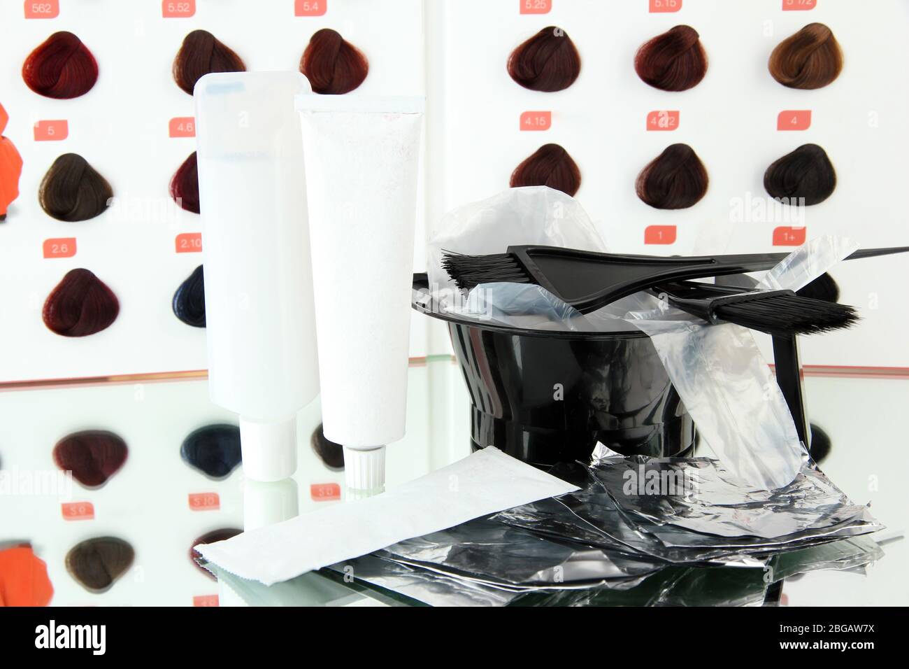 Hair dye kit on board with hair samples of different colors background ...