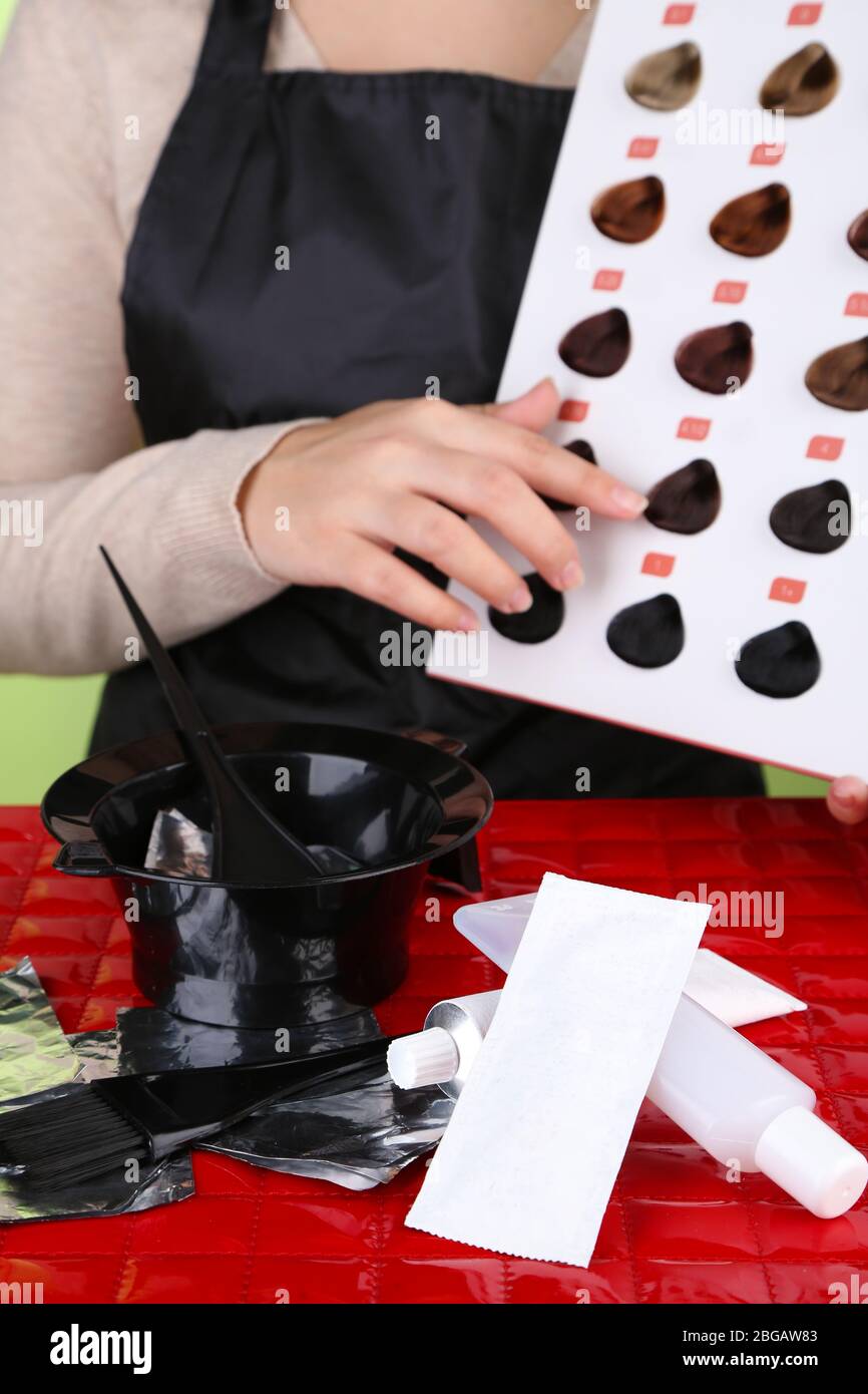 Hair stylist with hair dye kit and hair samples of different colors ...