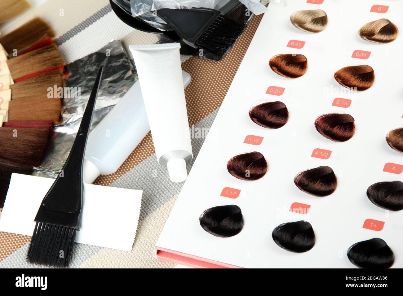 Hair dye kit on board with hair samples of different colors background ...