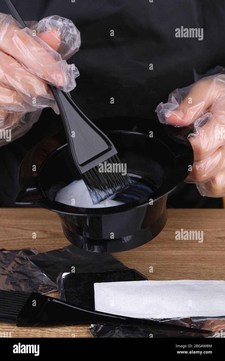 Hair stylist with hair dye kit and hair samples of different colors ...