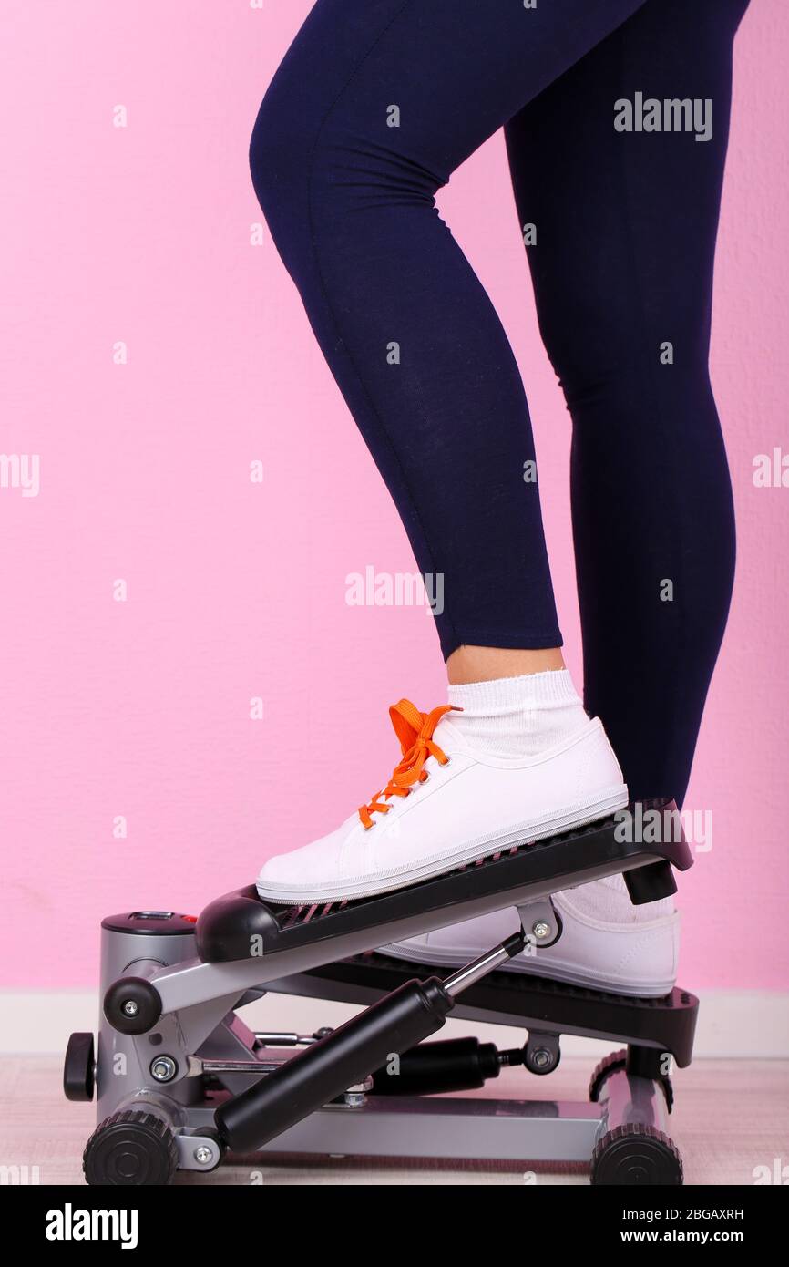 Woman doing exercise on stepper. Close-up on legs Stock Photo - Alamy