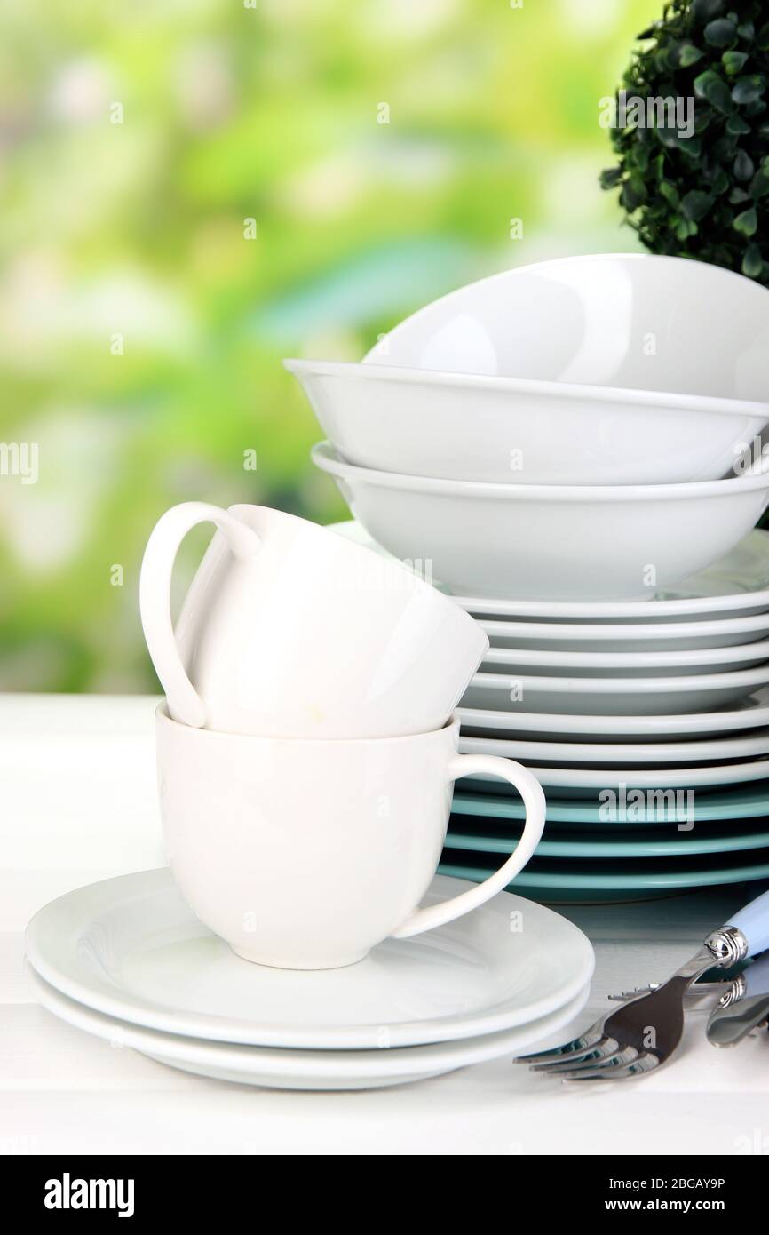 Clean dishes on table on natural background Stock Photo - Alamy