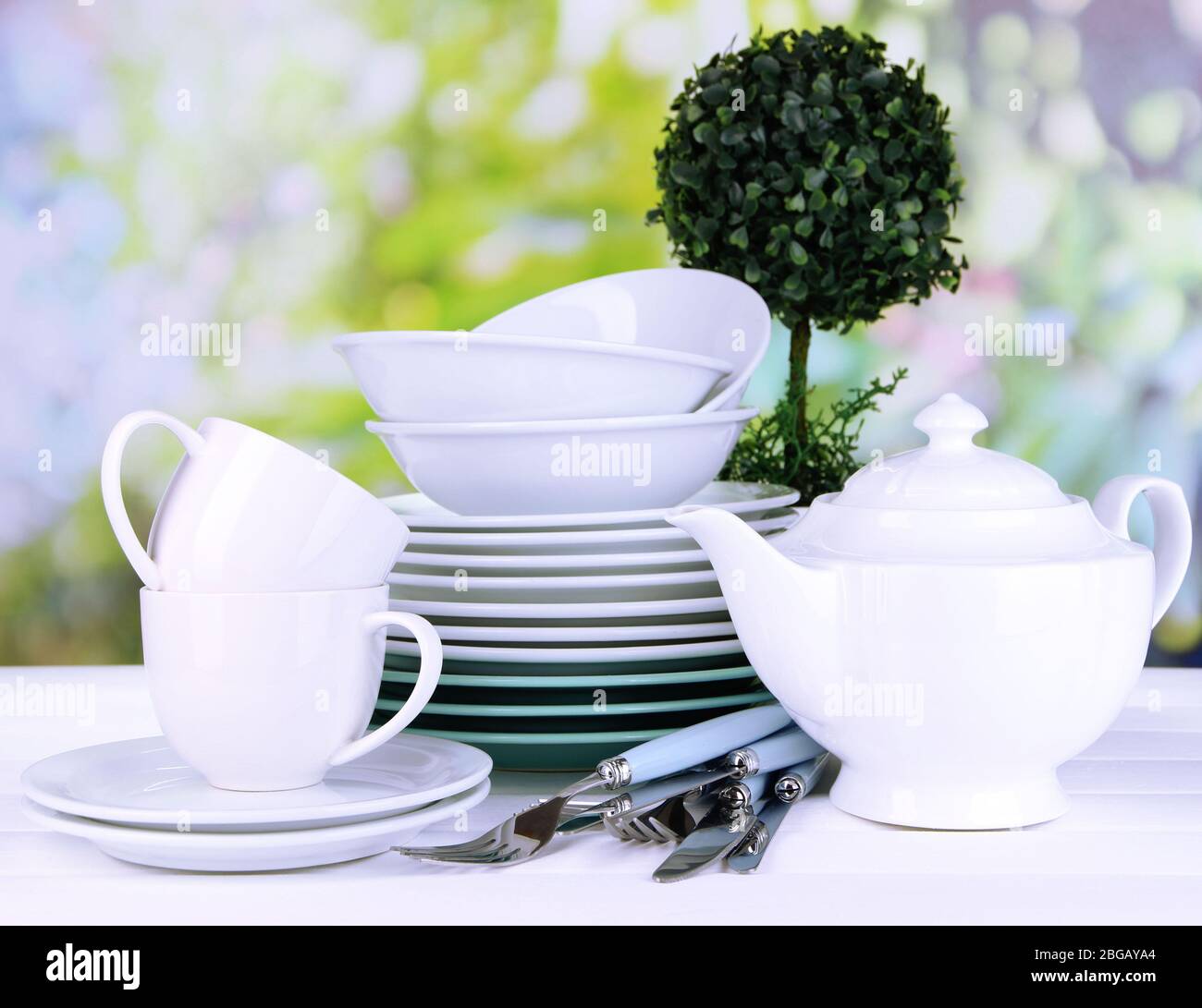 Clean dishes on table on natural background Stock Photo - Alamy