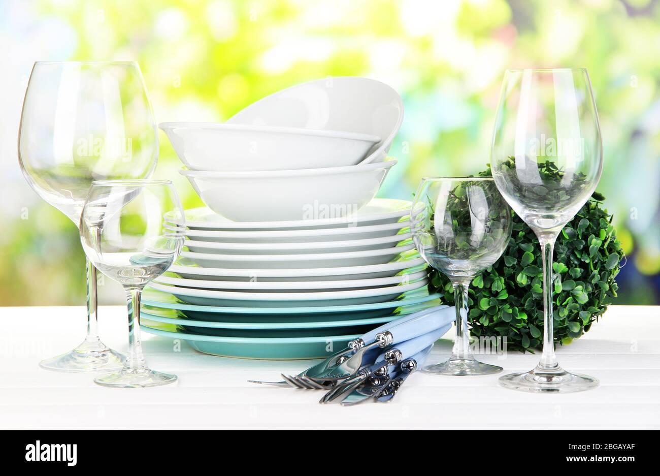 Clean dishes on table on natural background Stock Photo - Alamy