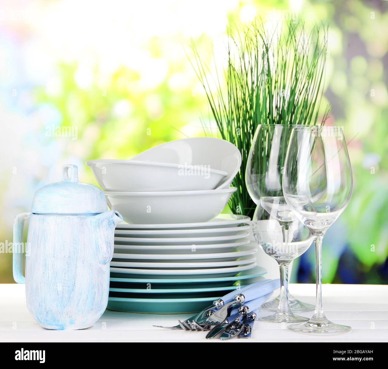 Clean dishes on table on natural background Stock Photo - Alamy