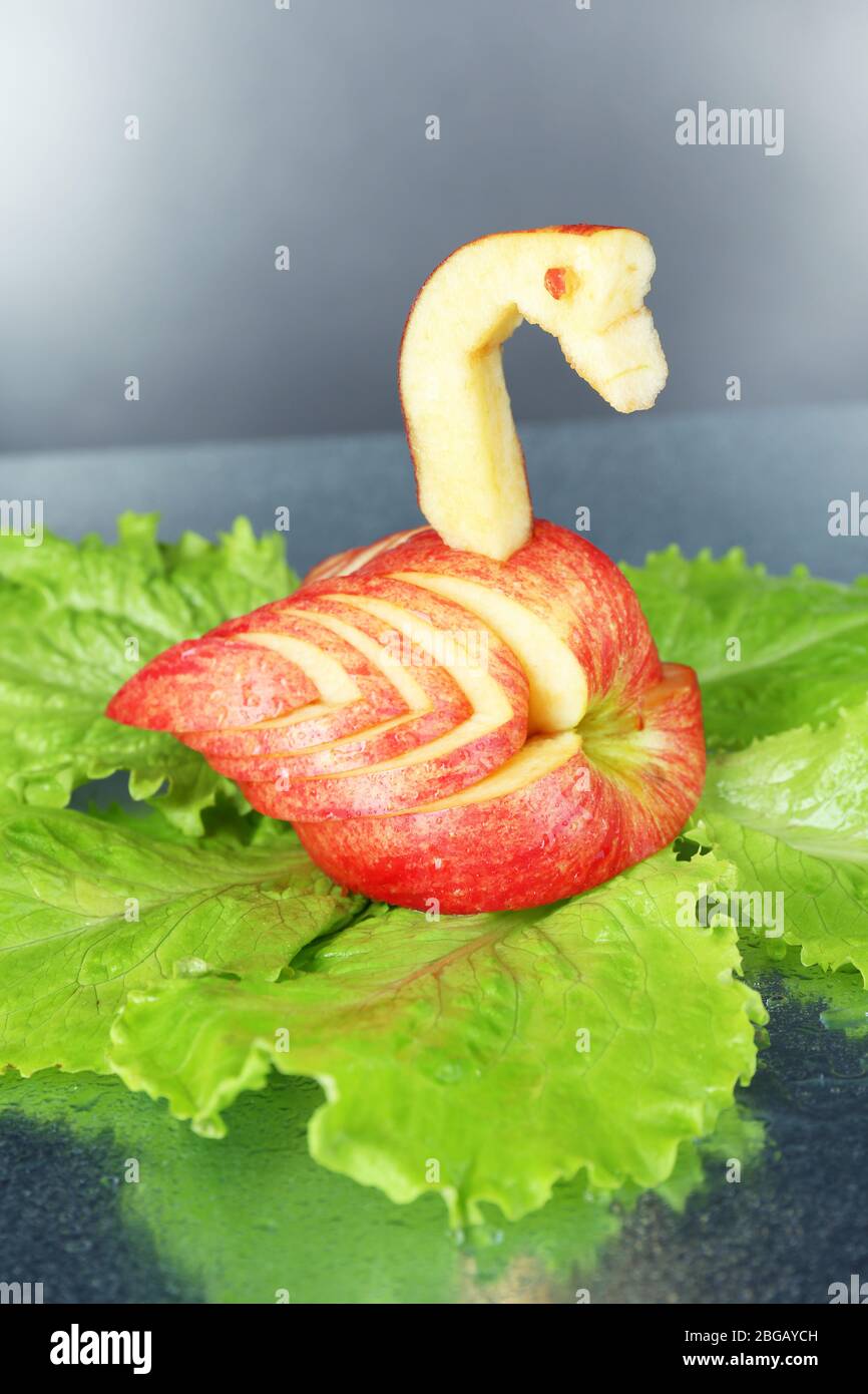 Carving fruit pattern of swan on grey wet background Stock Photo - Alamy