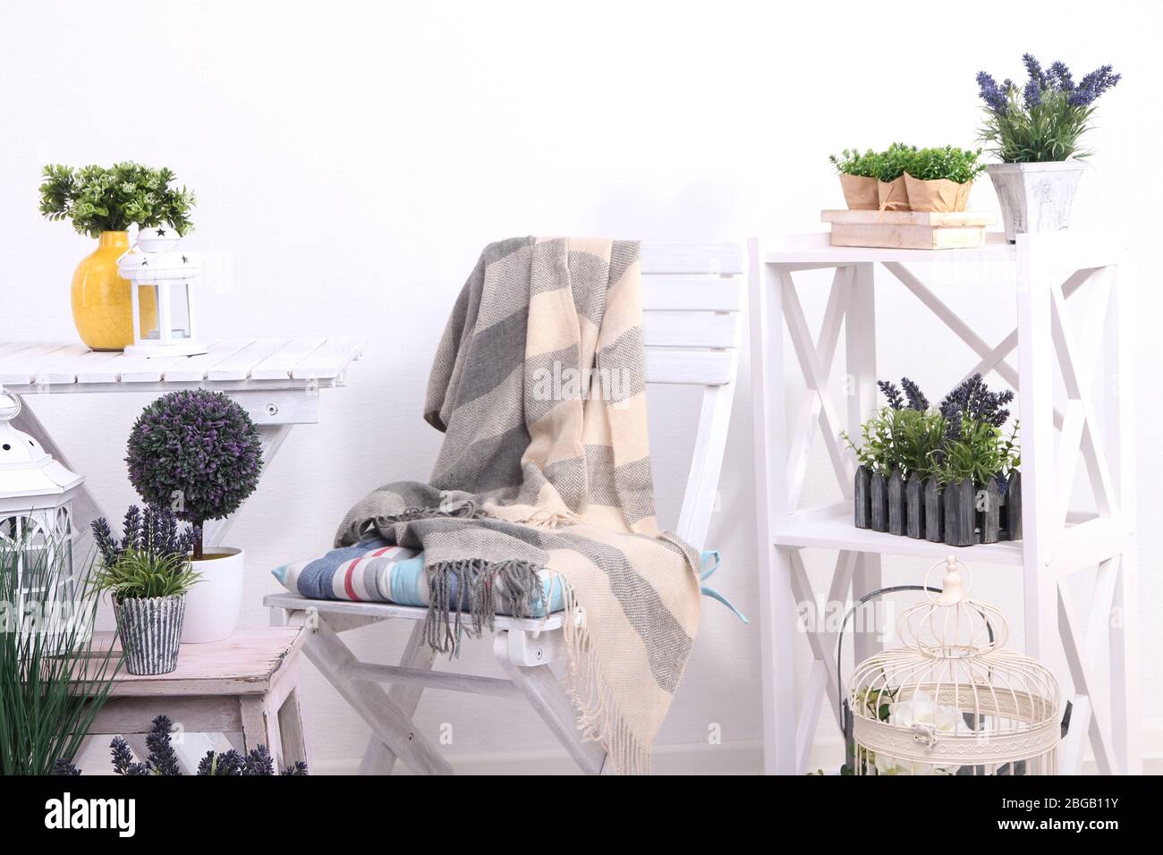 Garden chair and table with flowers on wooden stands on white ...