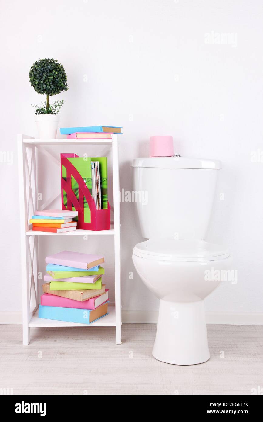 White toilet bowl and stand with books, on color wall background Stock ...