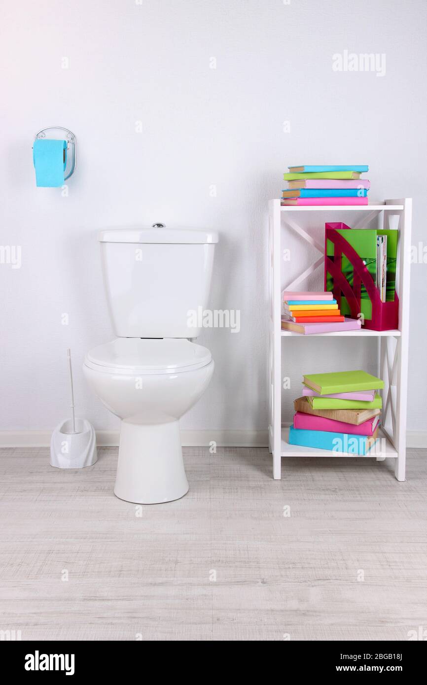 White toilet bowl and stand with books, on color wall background Stock ...