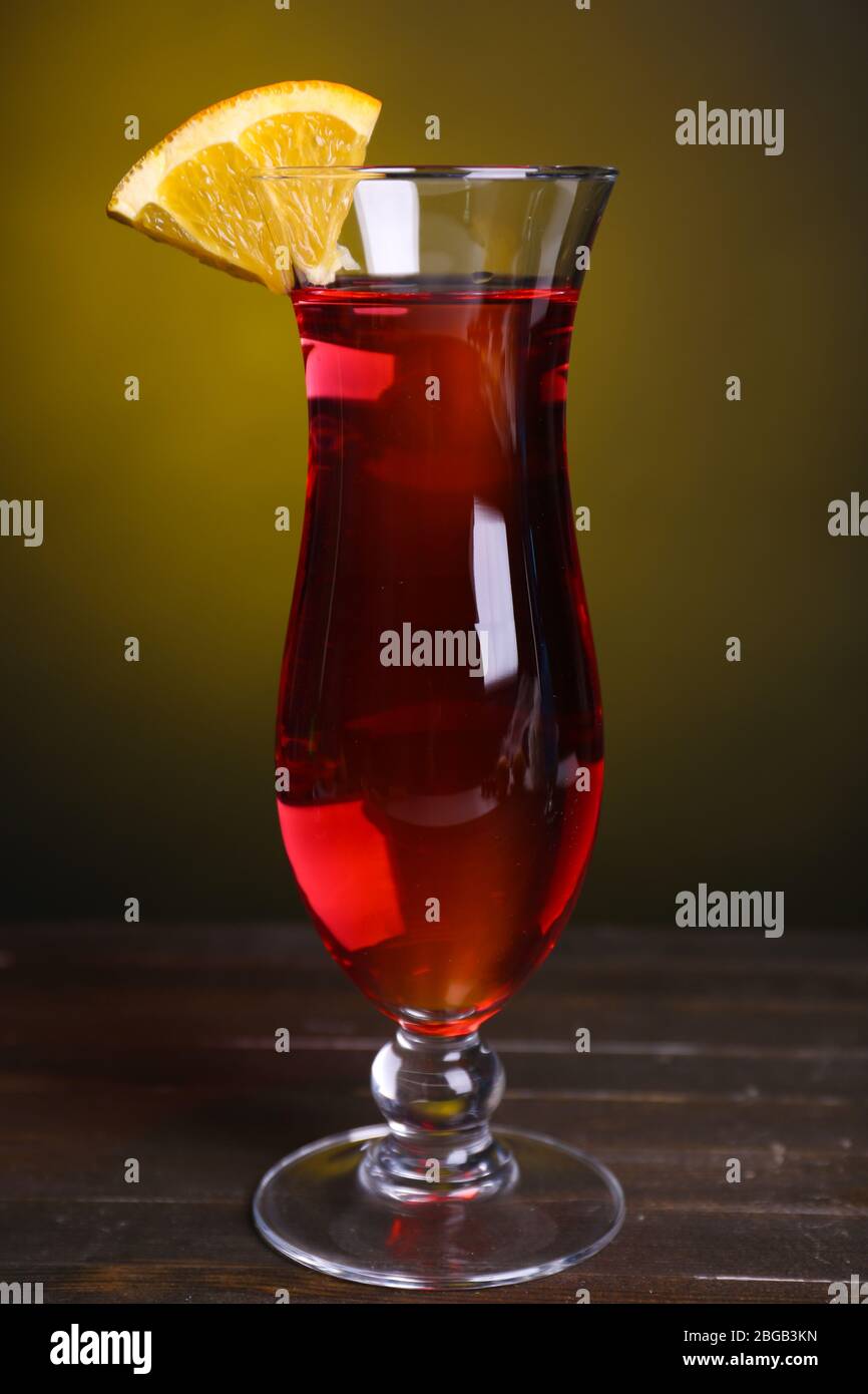 Glass of cocktail on table on dark yellow background Stock Photo - Alamy