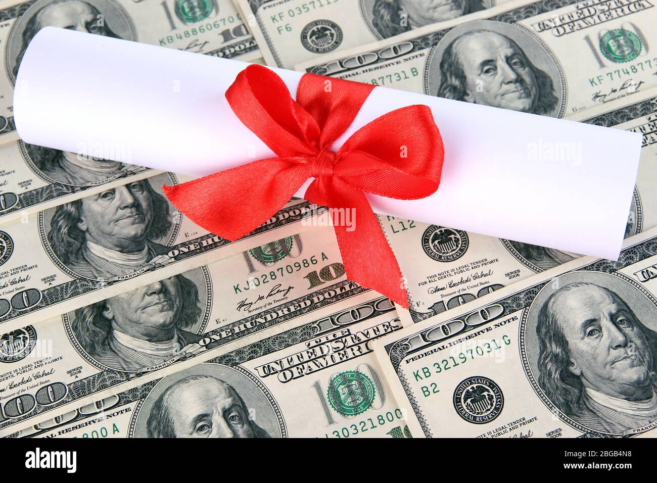 University diploma on dollars background. Cost of education. Conceptual ...
