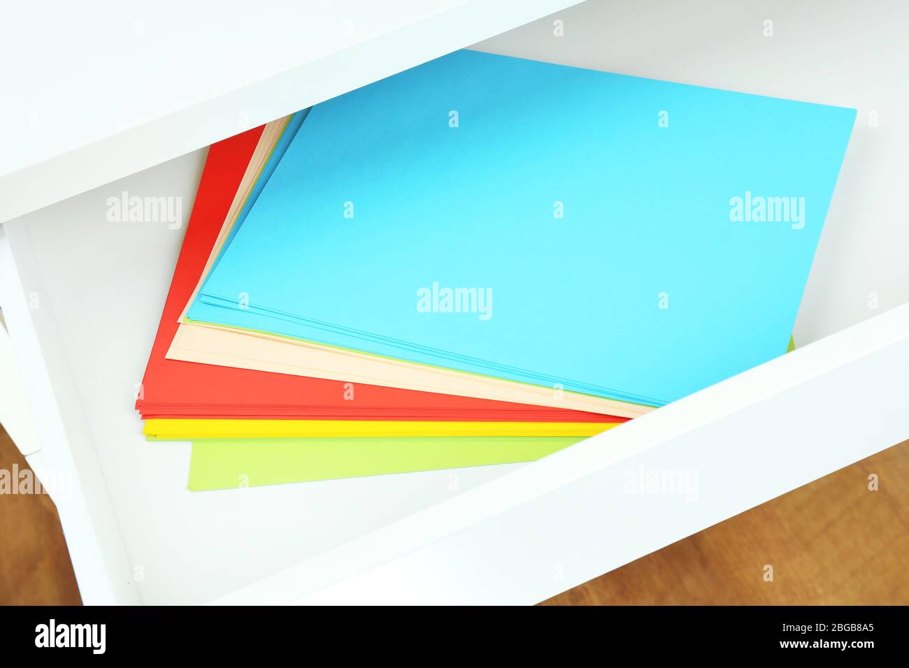 Colorful paper in open desk drawer close up Stock Photo - Alamy
