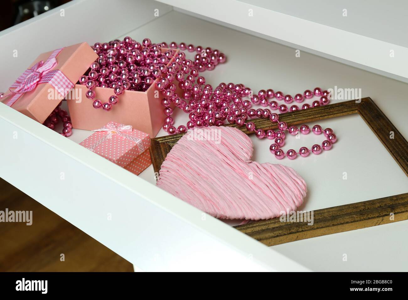 Gift box and beads in open desk drawer close up Stock Photo - Alamy