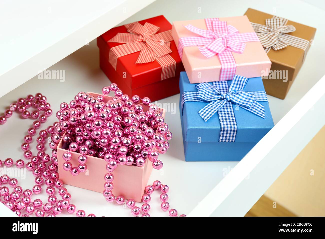 Gift boxes and beads in open desk drawer close up Stock Photo - Alamy