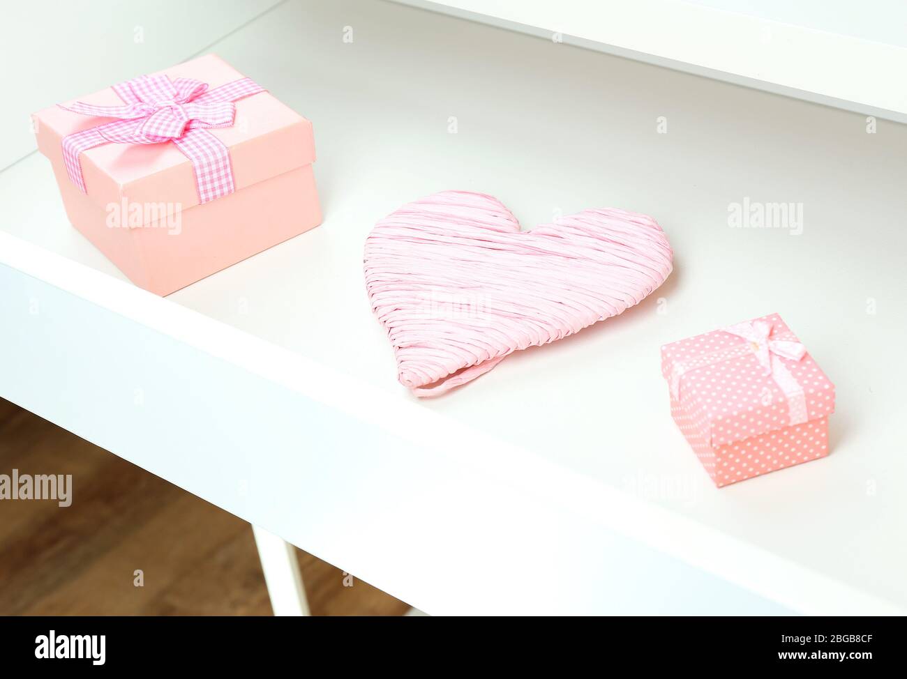 Gift boxes and heart in open desk drawer close up Stock Photo - Alamy