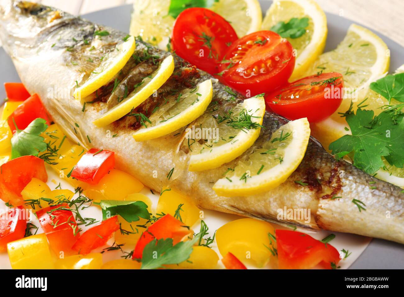 Delicious grilled fish on plate on table close-up Stock Photo - Alamy