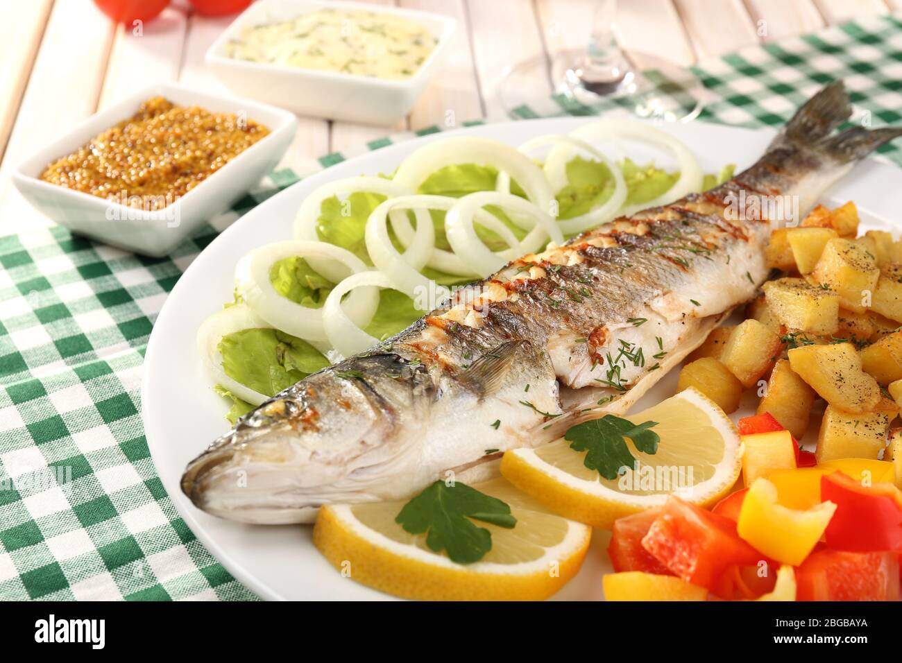 Delicious grilled fish on plate on table close-up Stock Photo - Alamy