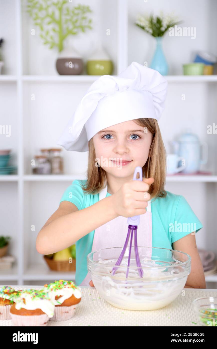 Little girl eating cream in kitchen at home Stock Photo - Alamy