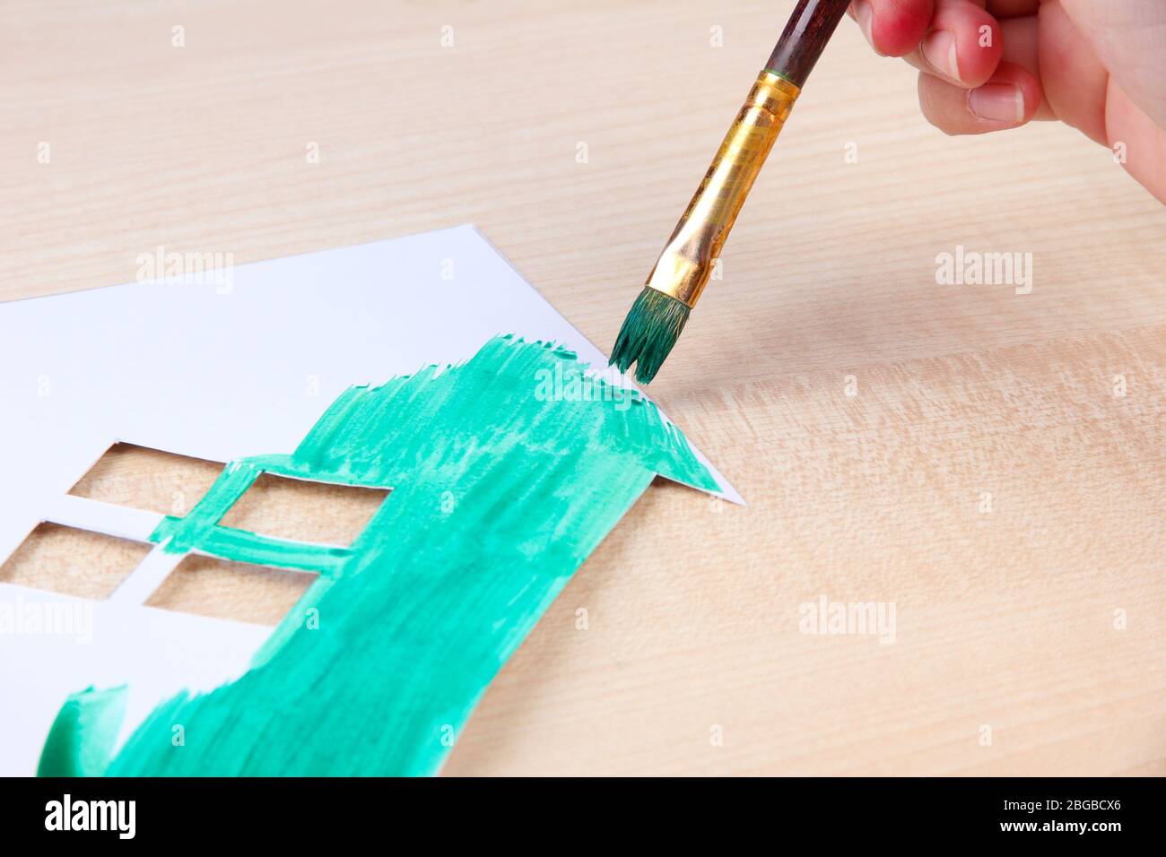 Female hand coloring paper cabin, on wooden background Stock Photo - Alamy