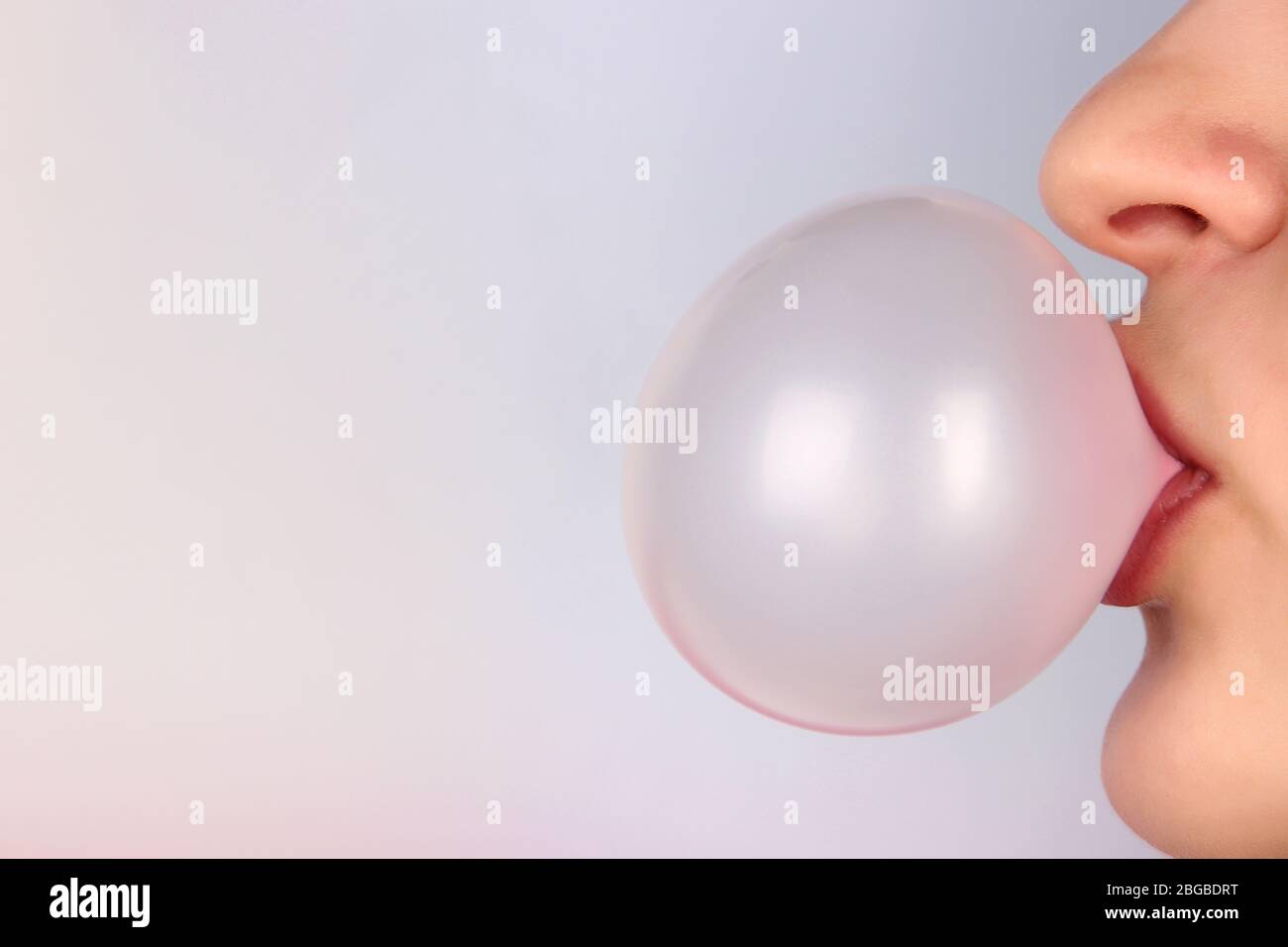 Person doing bubble with chewing gum on bright background Stock Photo ...