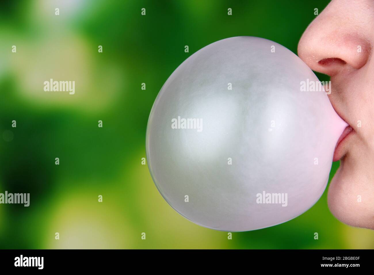 Person doing bubble with chewing gum on bright background Stock Photo ...