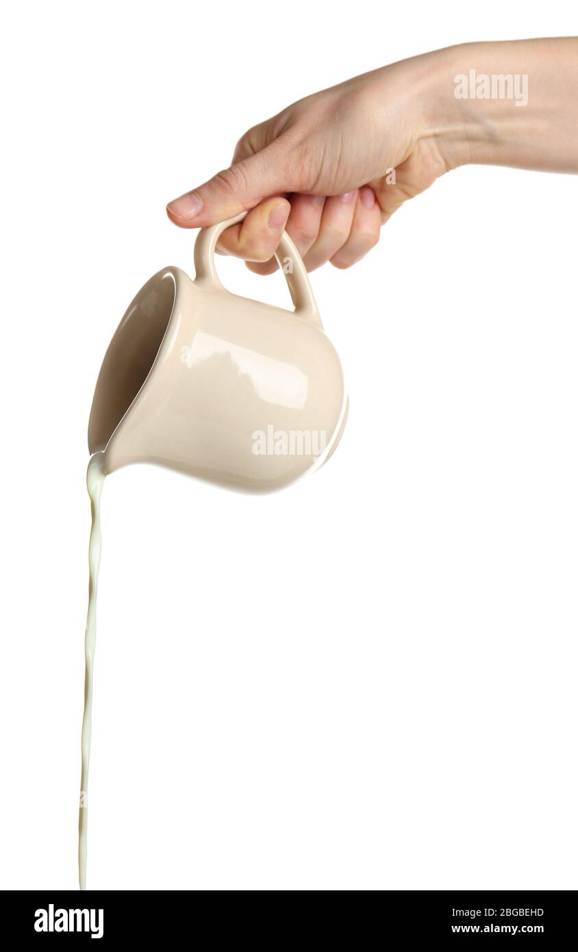 Pouring milk from pitcher, isolated on white Stock Photo - Alamy