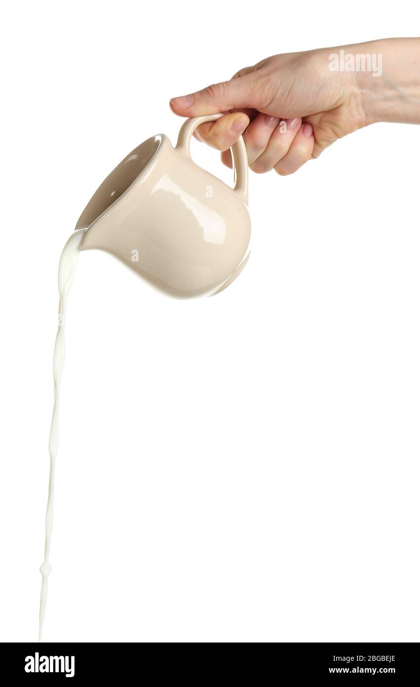 Pouring milk from pitcher, isolated on white Stock Photo - Alamy
