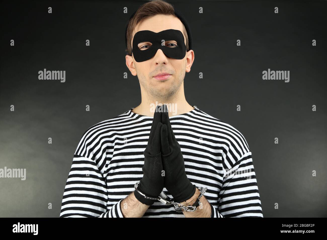 Thief with handcuffs on dark background Stock Photo - Alamy