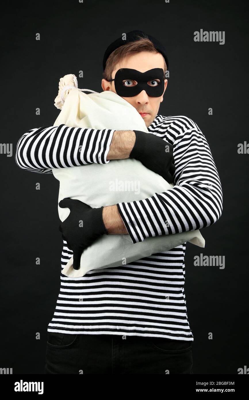 Thief with bag isolated on black Stock Photo - Alamy