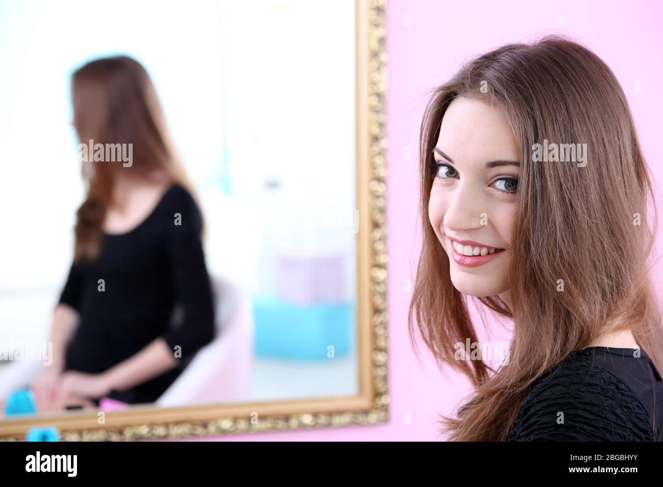 Young beautiful woman sitting front of mirror in room Stock Photo - Alamy