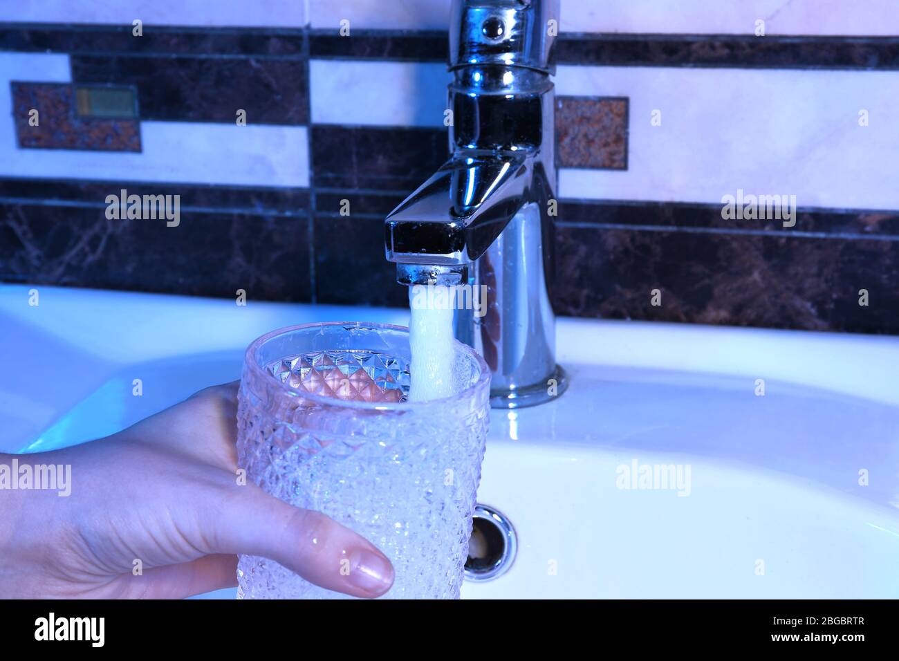 Filling up glass of water Stock Photo - Alamy