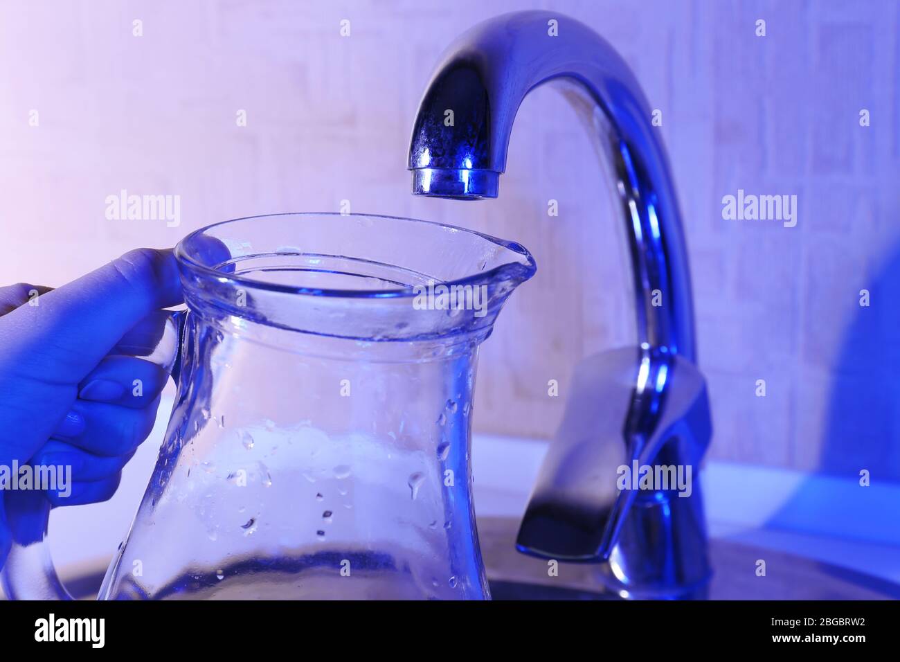Filling up glass pitcher of water Stock Photo - Alamy