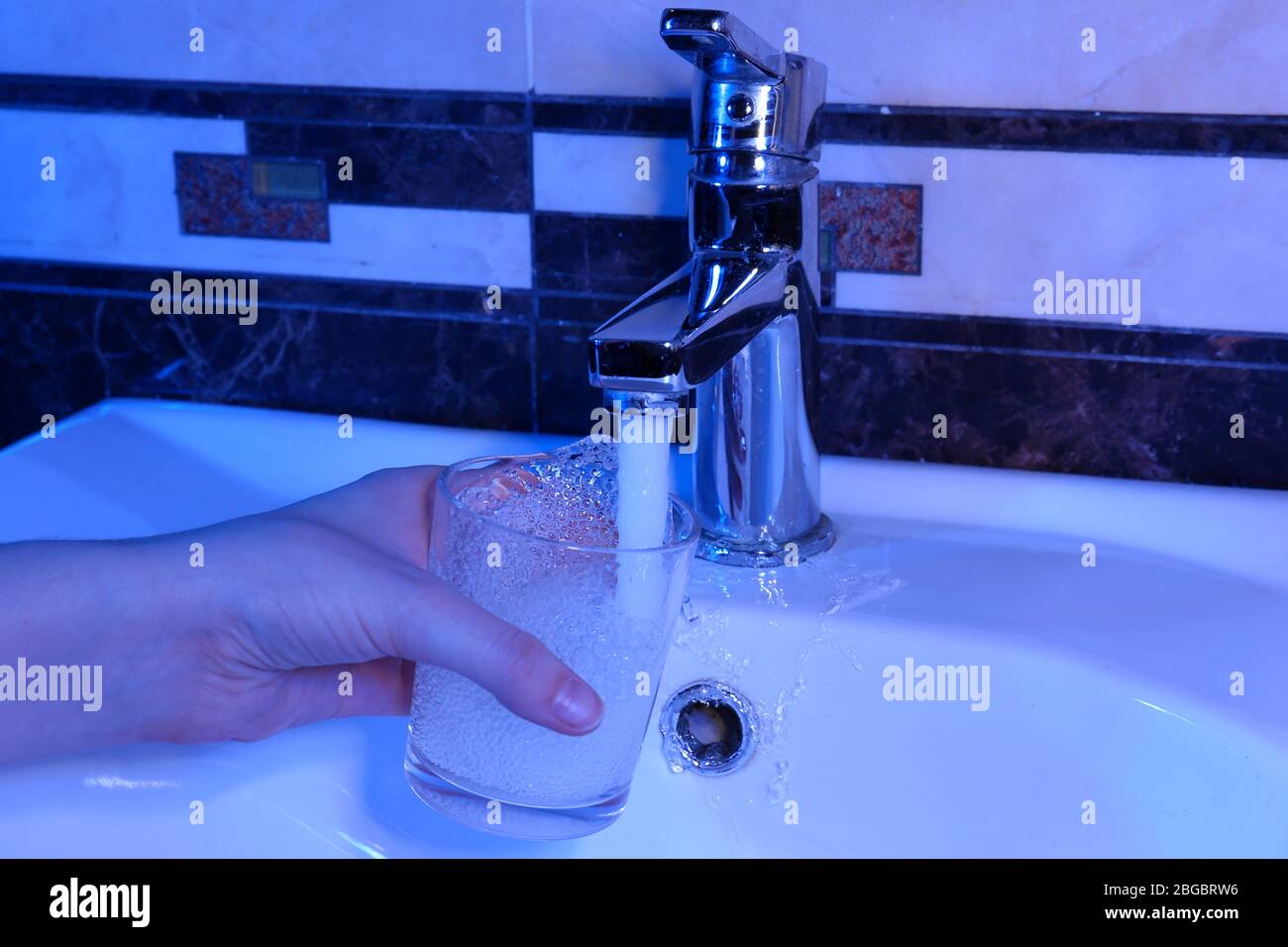 Filling up glass of water Stock Photo - Alamy