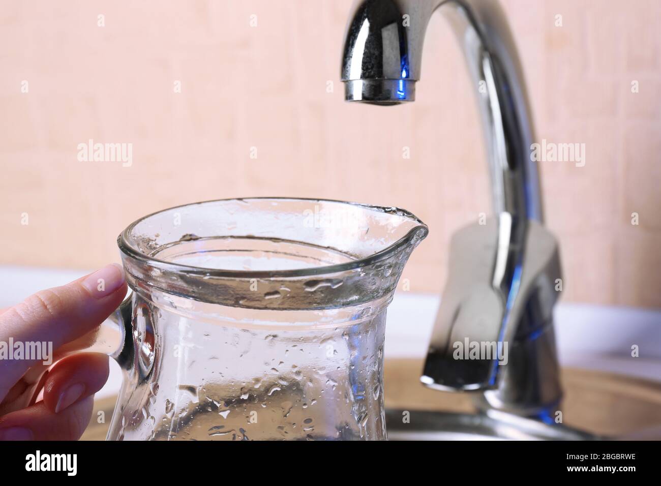 Filling up glass pitcher of water Stock Photo - Alamy