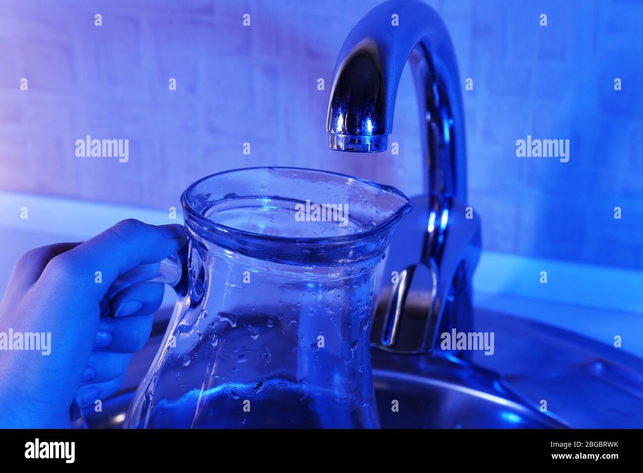 Filling up glass pitcher of water Stock Photo - Alamy