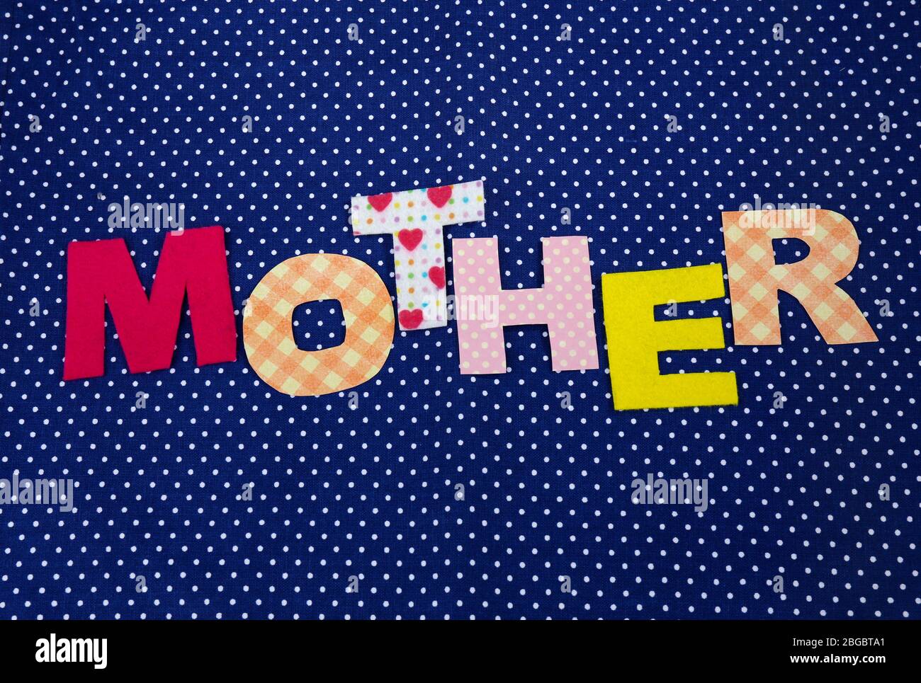 Mother- lettering of handmade paper letters on blue polka background ...