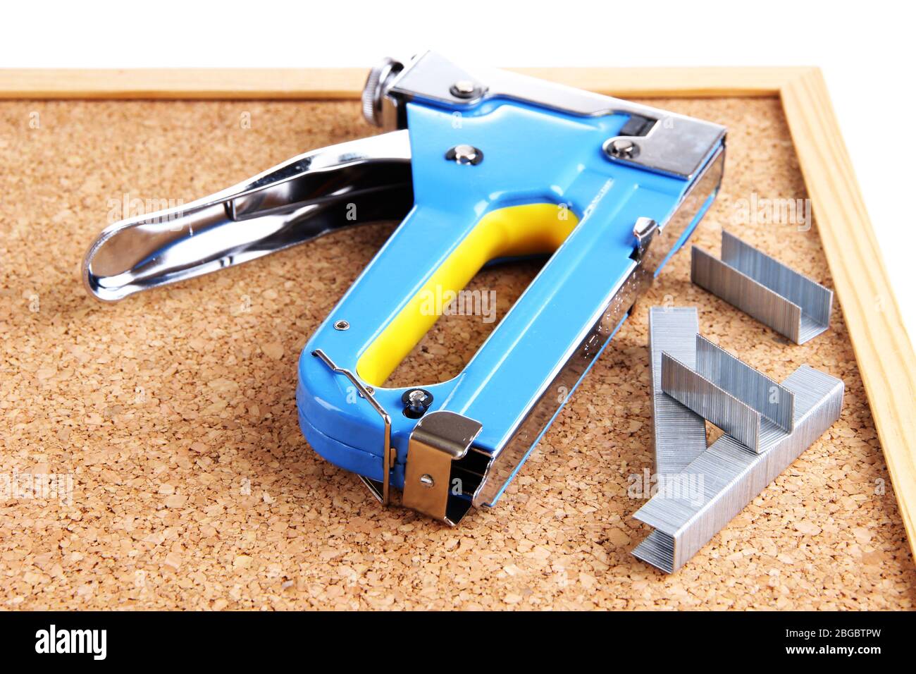 Construction stapler and staples on cork board close up Stock Photo - Alamy
