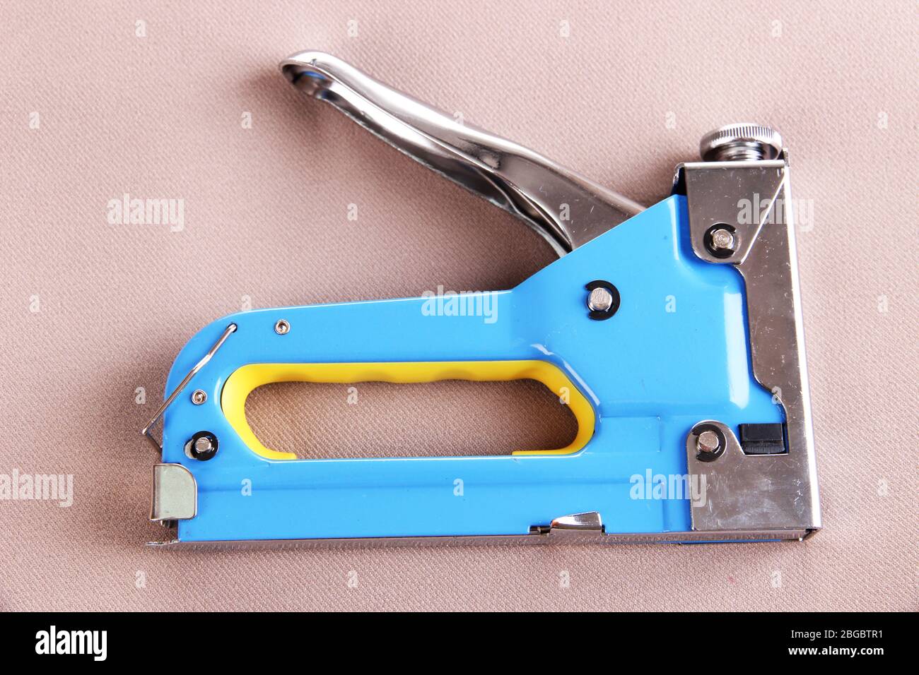 Construction stapler on fabric close up Stock Photo - Alamy