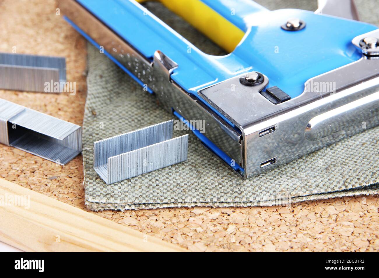 Construction stapler and staples on cork board close up Stock Photo - Alamy