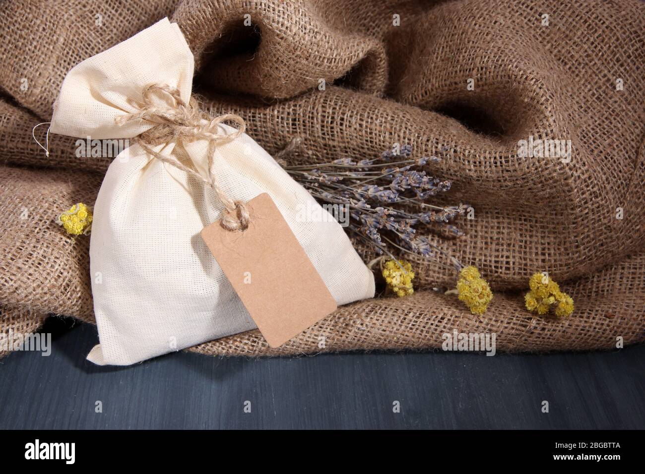 Textile sachet pouch with dried flowers, herbs on wooden table, on ...