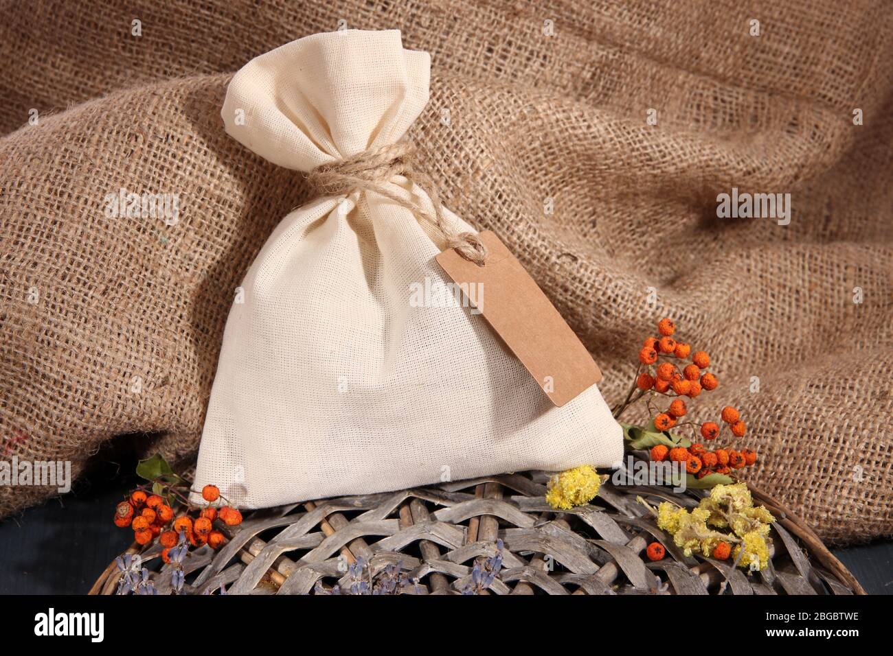 Textile sachet pouch with dried flowers, herbs and berries on wooden ...