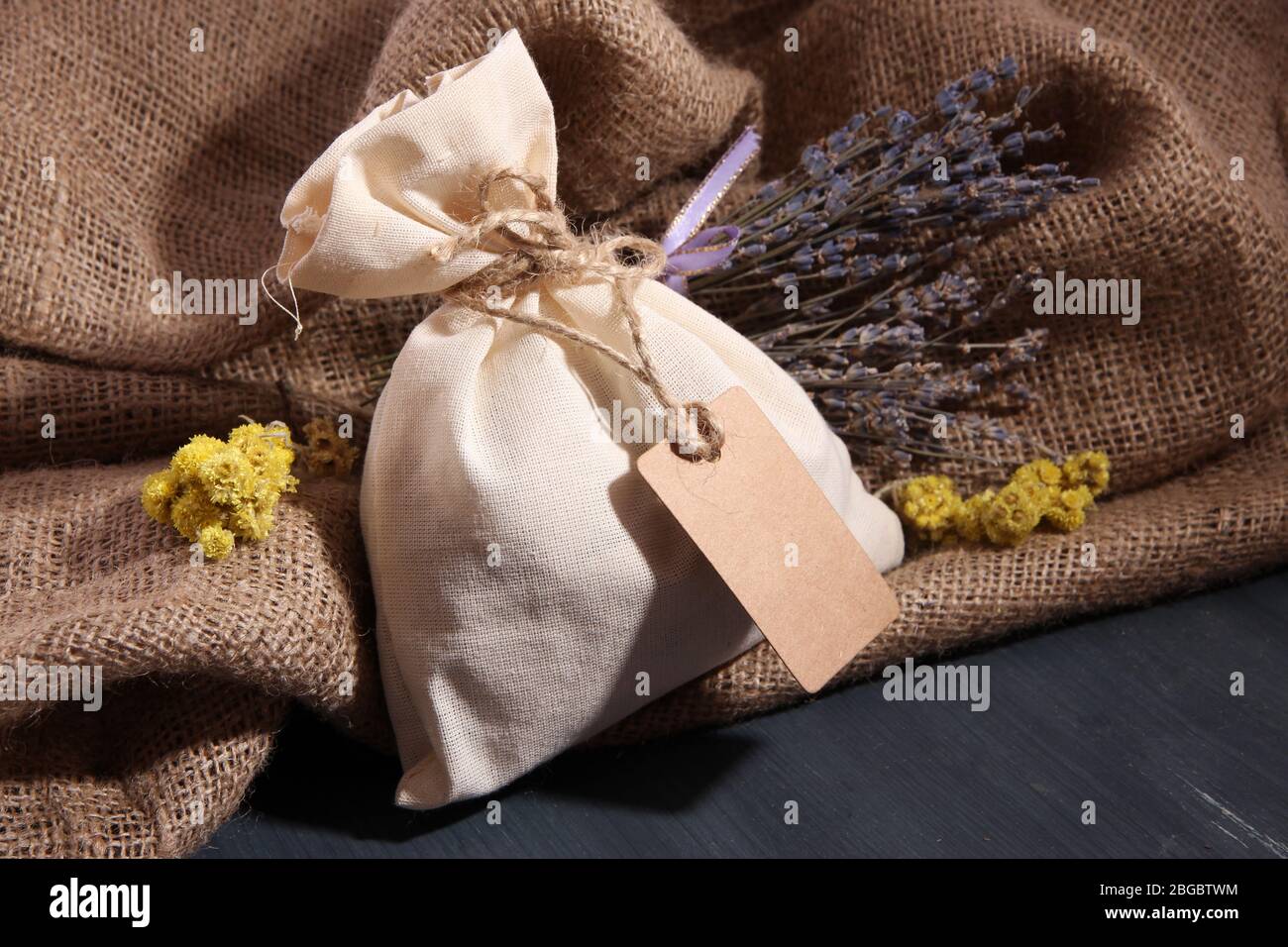 Textile sachet pouch with dried flowers, herbs on wooden table, on ...