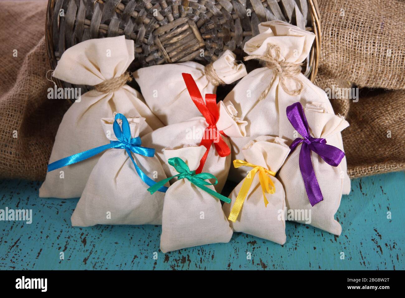 Sacks on color wooden table, on sackcloth background Stock Photo - Alamy