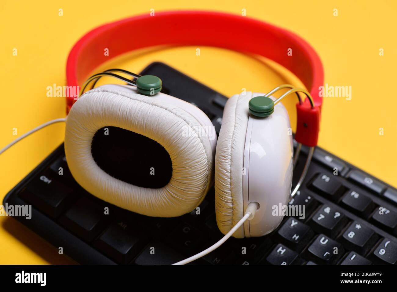 Earphones in red and white colors with computer keyboard. Sound ...