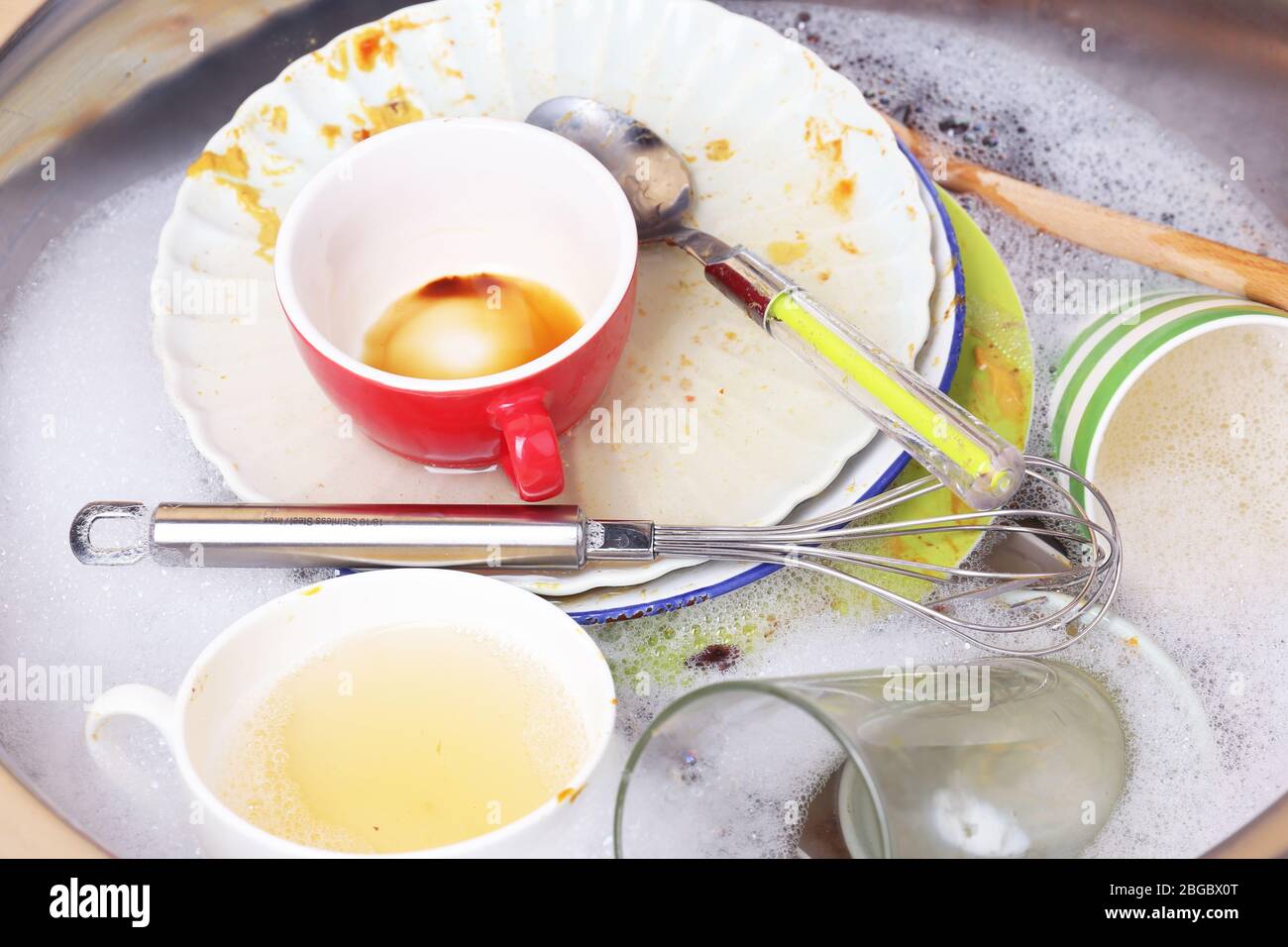 Utensils soaking in kitchen sink Stock Photo - Alamy