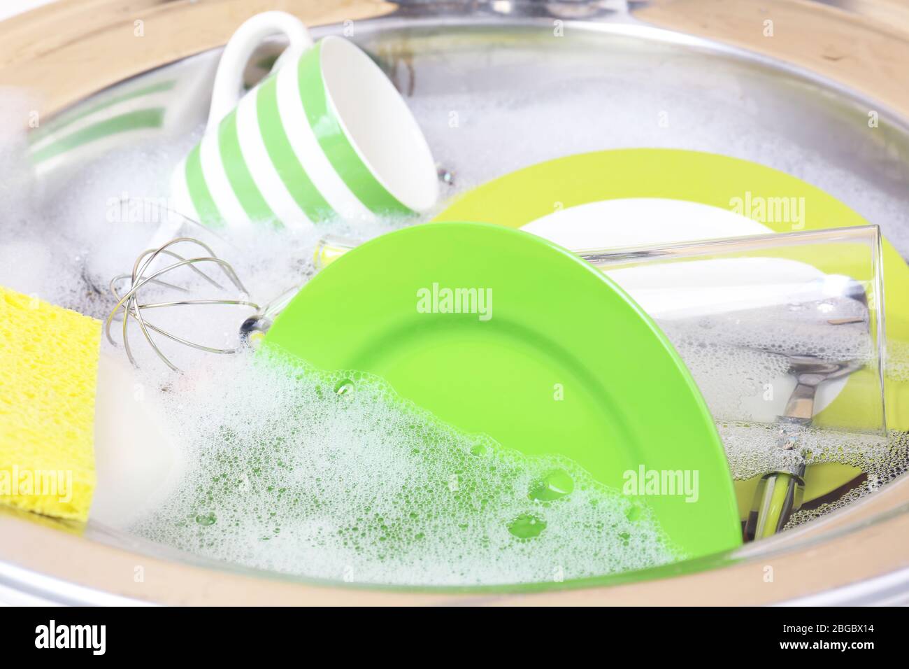 Utensils soaking in kitchen sink Stock Photo - Alamy