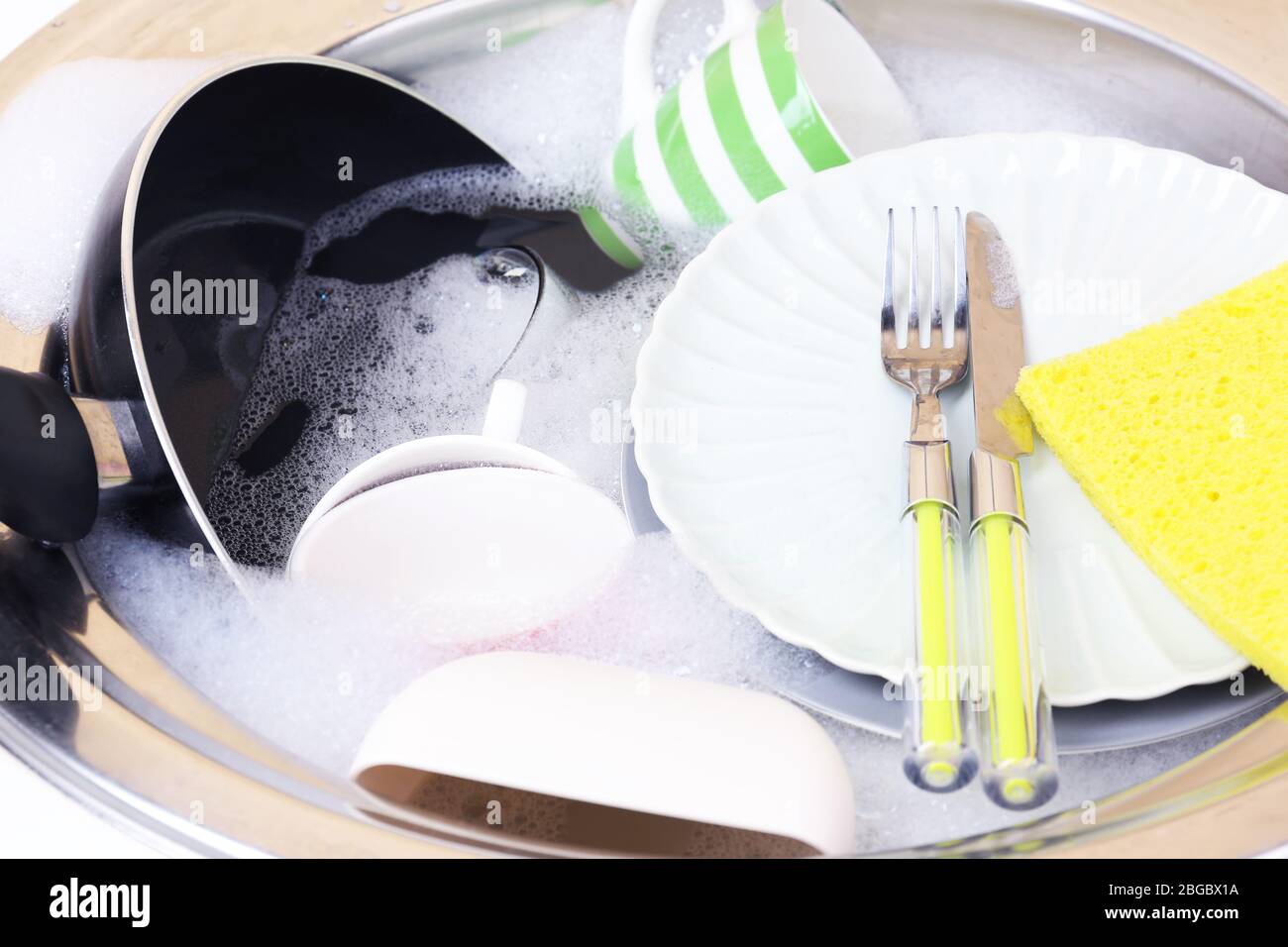 Utensils soaking in kitchen sink Stock Photo - Alamy
